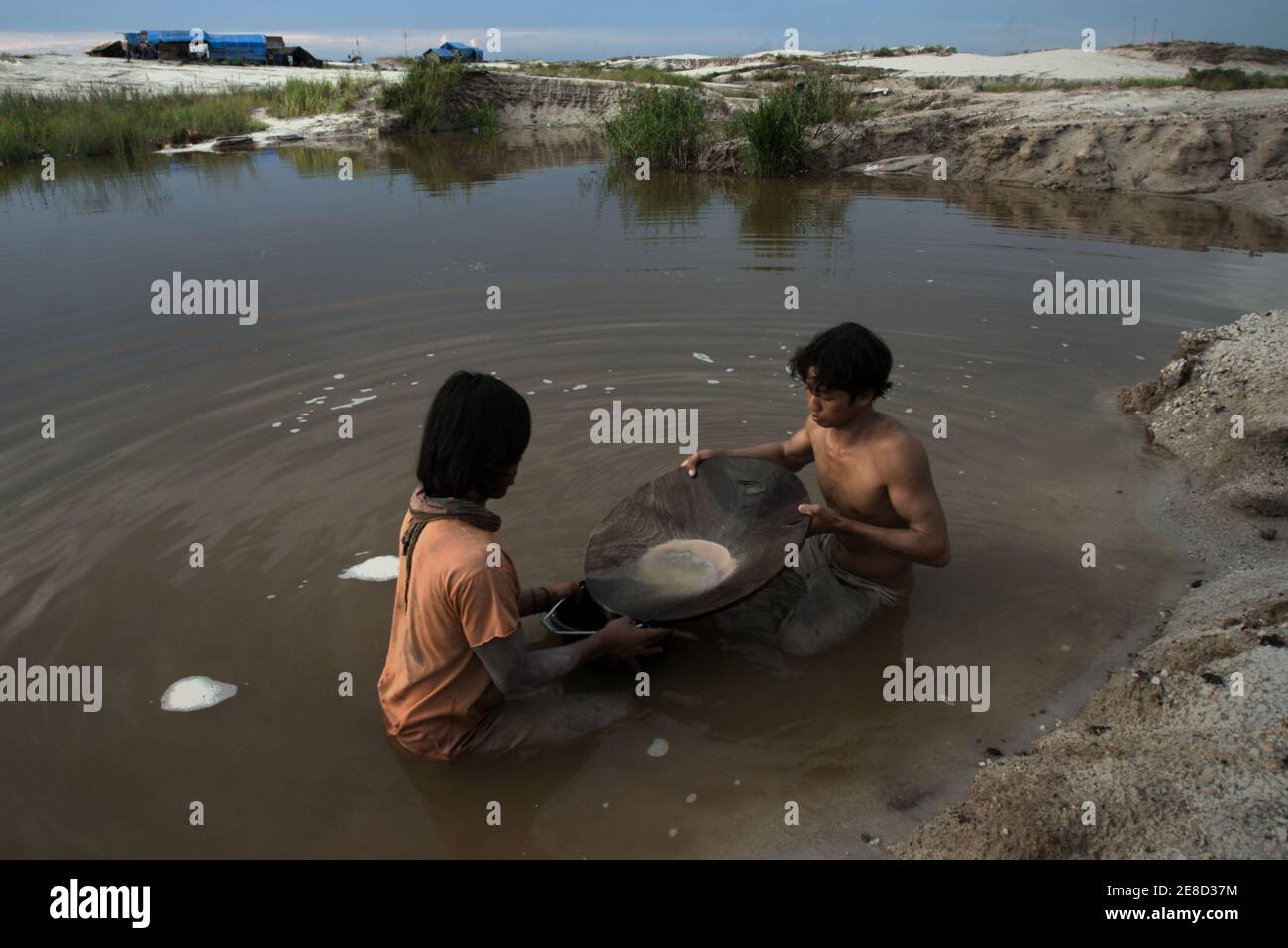 Gold miners panning for gold on a pond in a small-scale gold mining ...