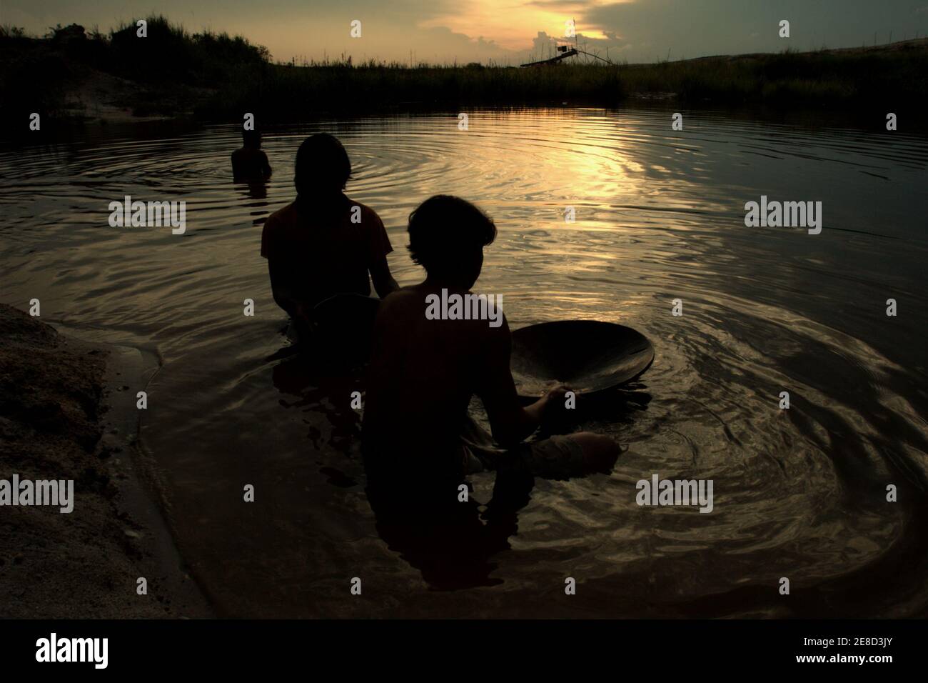 Gold miners panning for gold on a pond in a small-scale gold mining ...