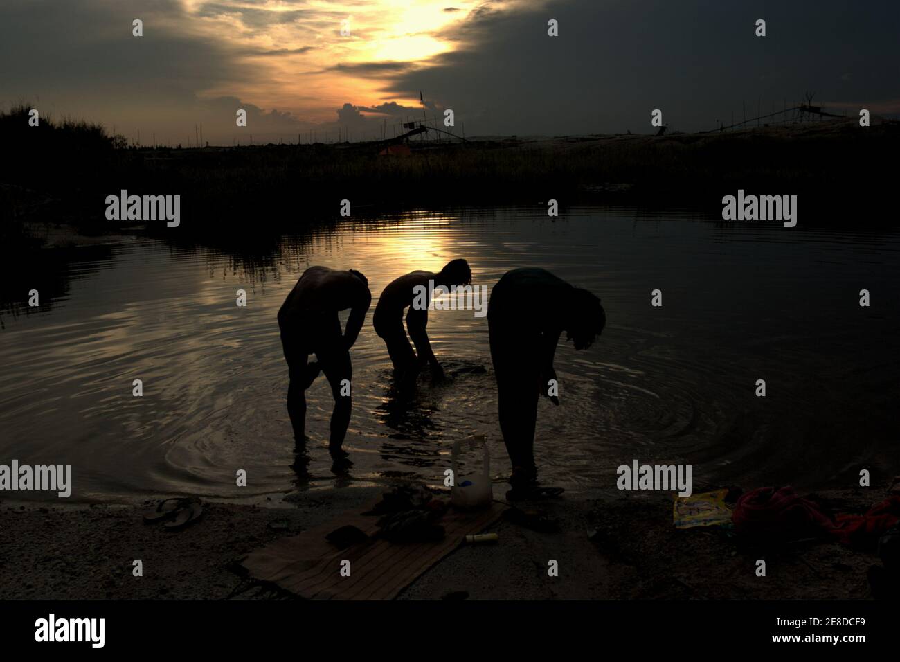 Gold miners silhouetted against a bright sunlight as they are taking a ...