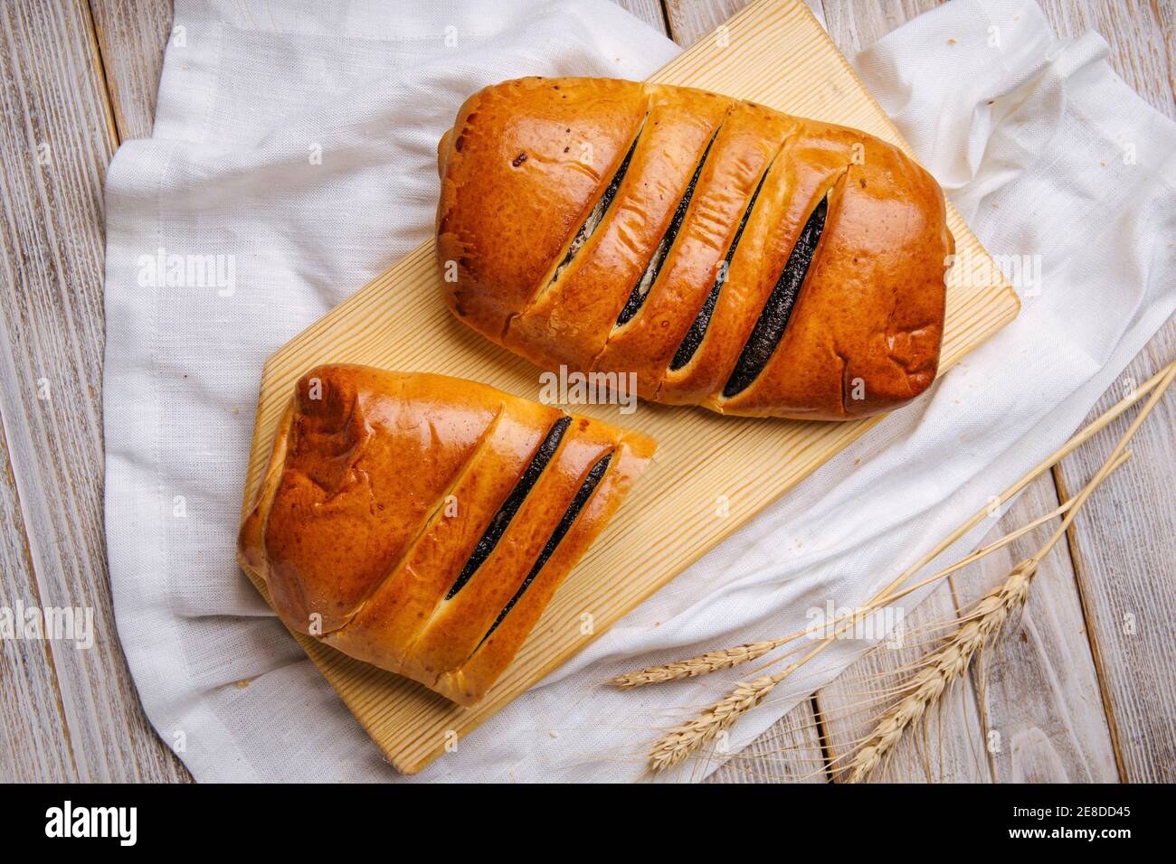 Top view on cut poppy seed bun on the wooden board Stock Photo - Alamy