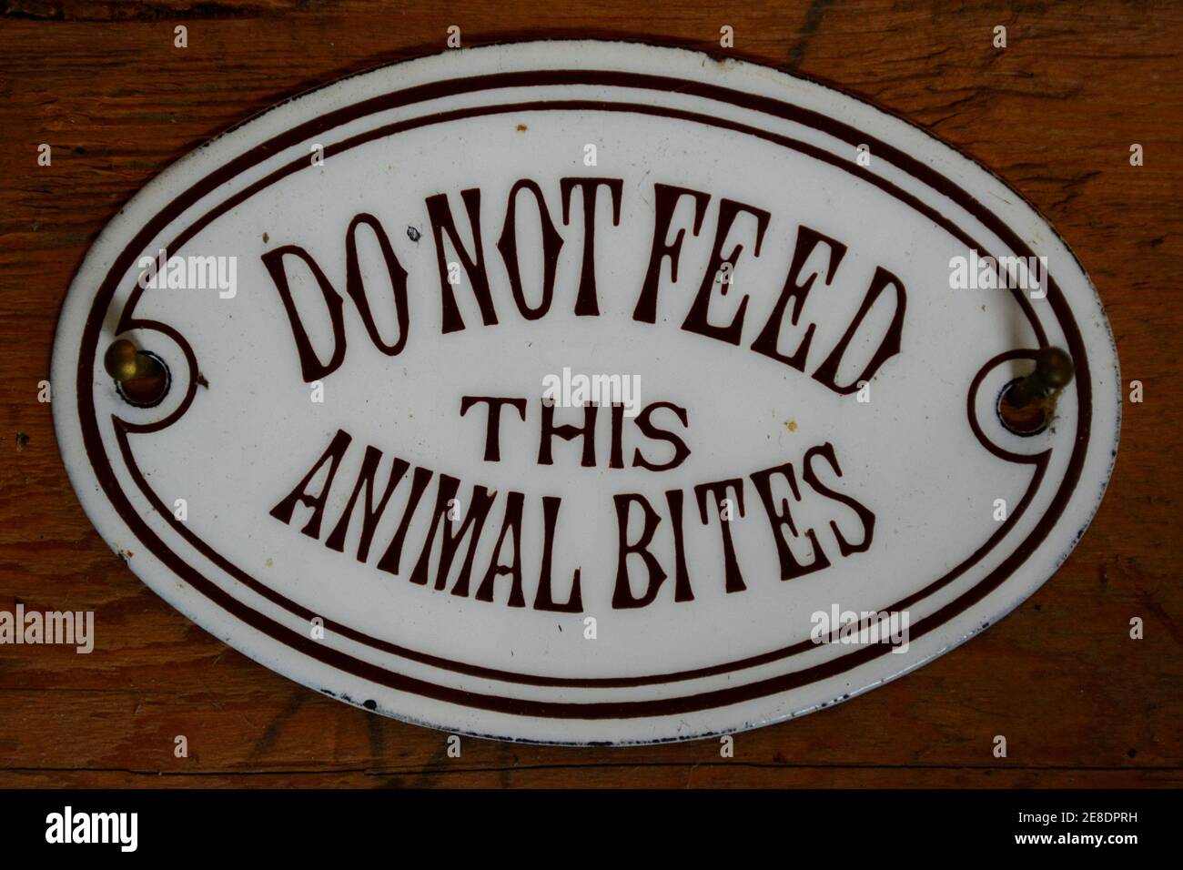 A "Do not feed This animal bites" metal sign on wooden background Stock ...