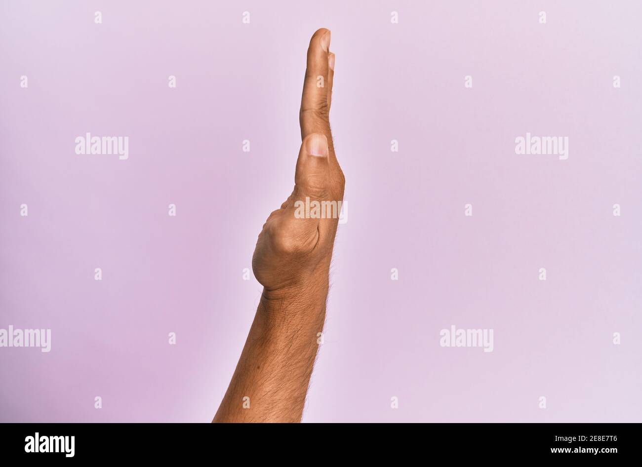 Arm and hand of caucasian young man over pink isolated background ...