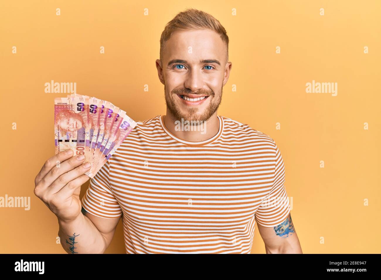 Young caucasian man holding south african 50 rand banknotes looking ...