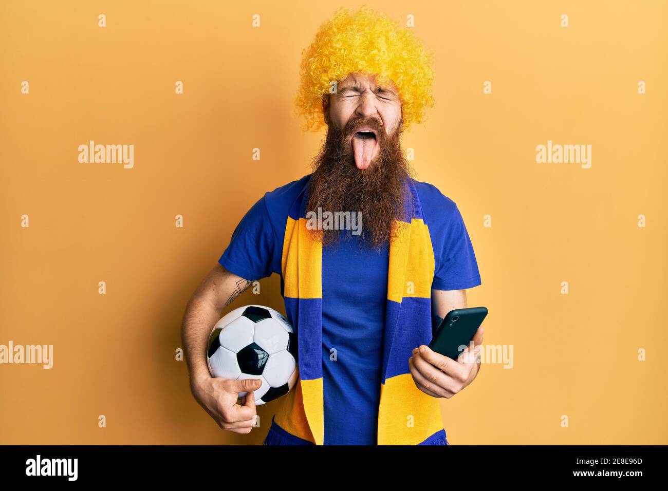Redhead man with long beard football hooligan cheering game holding ...