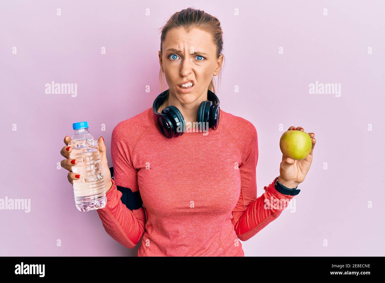 Beautiful caucasian sports woman holding water bottle and green apple ...