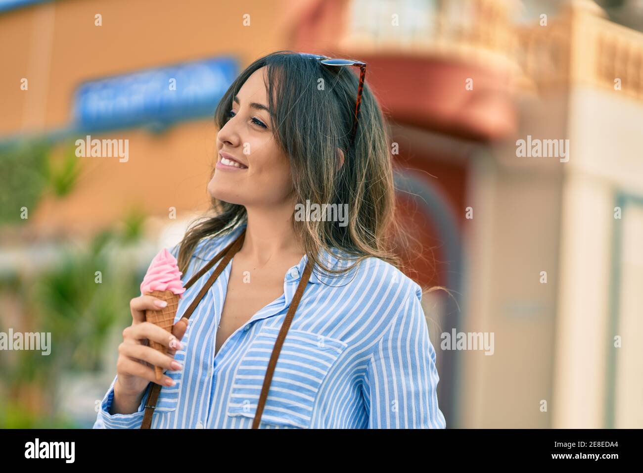 Young hispanic woman smiling happy eating ice cream at the city Stock ...