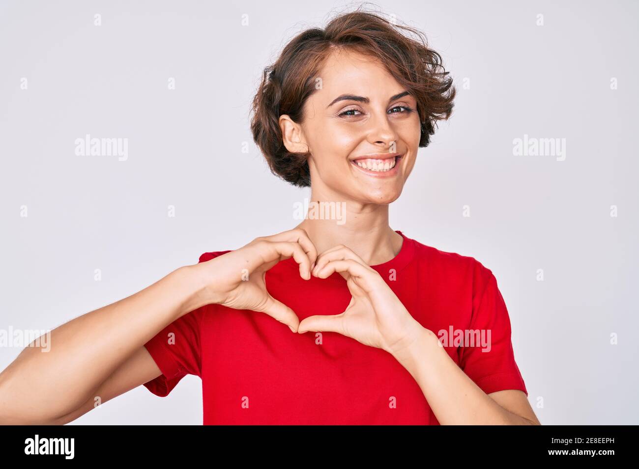 Young hispanic woman wearing casual clothes smiling in love doing heart ...