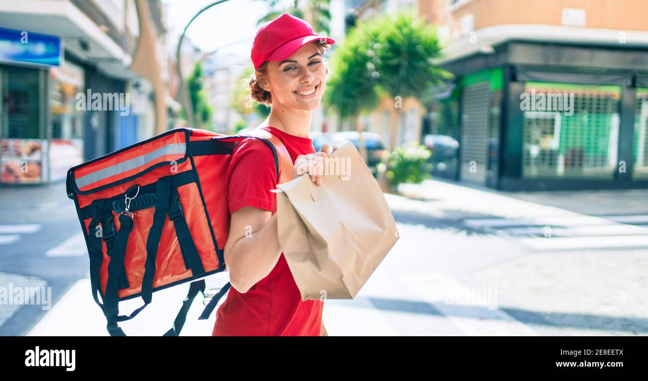 Delivery business worker woman wearing uniform and delivery bag smiling ...