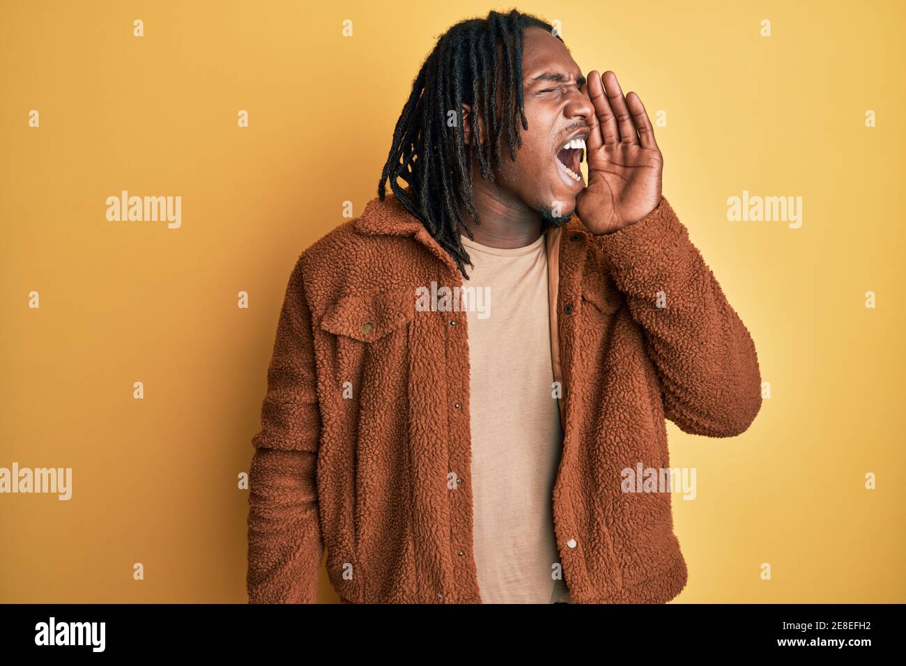 African american man with braids wearing brown retro jacket shouting ...