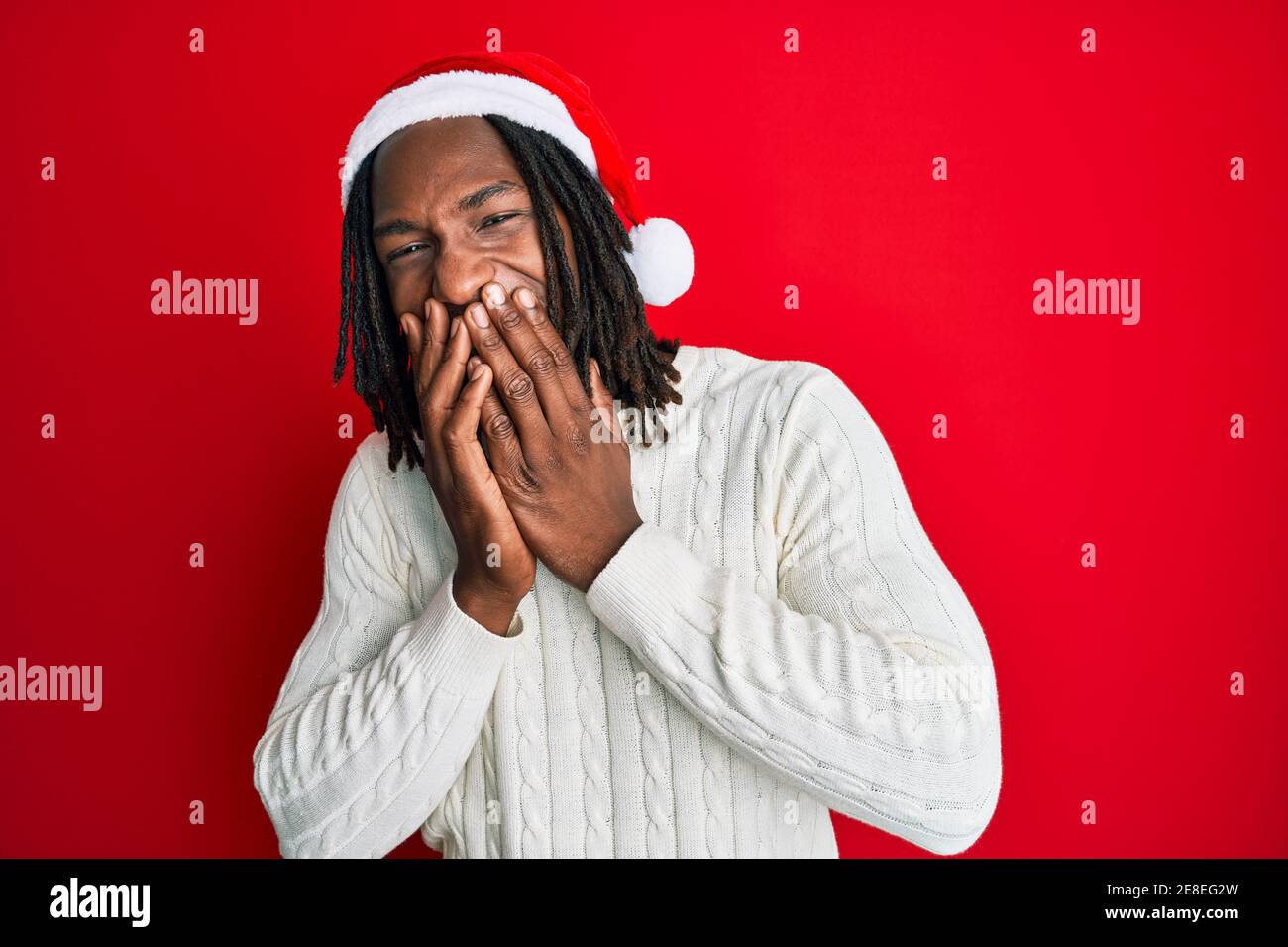 African american man with braids wearing christmas hat laughing and ...