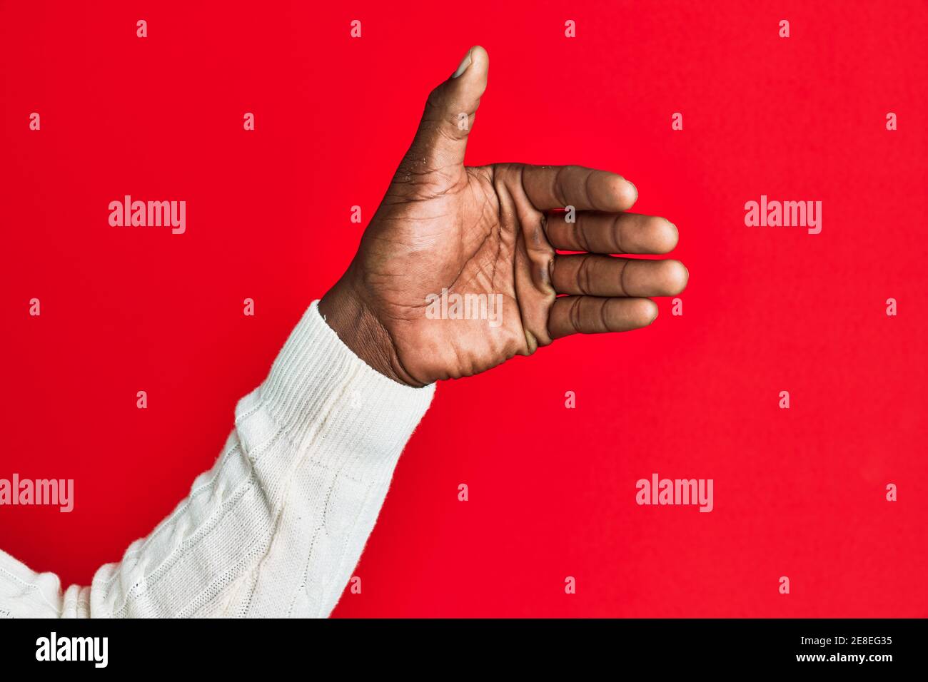 Arm and hand of african american black young man over red isolated ...