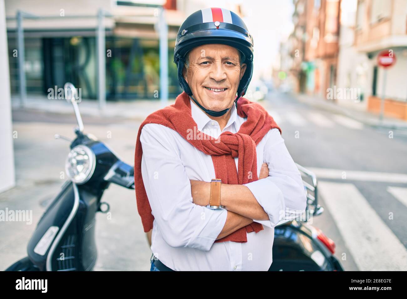 Senior motorcyclist man smiling happy wearing moto helmet at the city ...