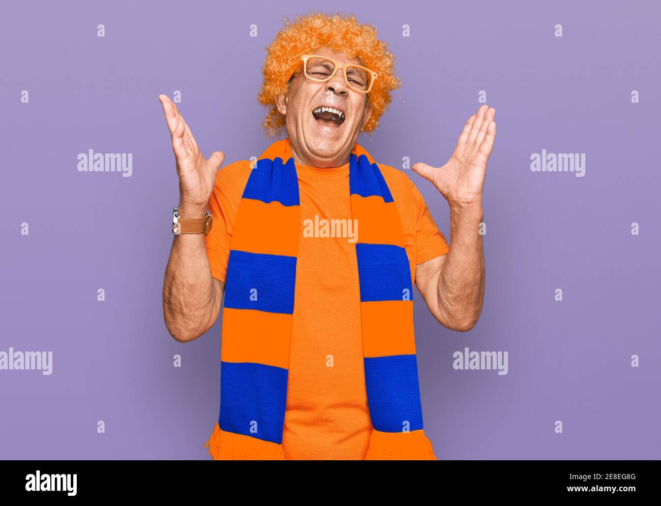Senior hispanic man football hooligan cheering game celebrating mad and ...