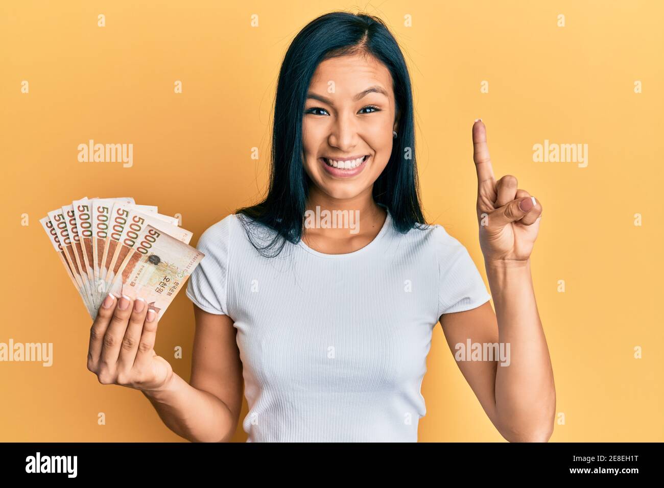 Beautiful hispanic woman holding 5000 south korean won banknotes ...