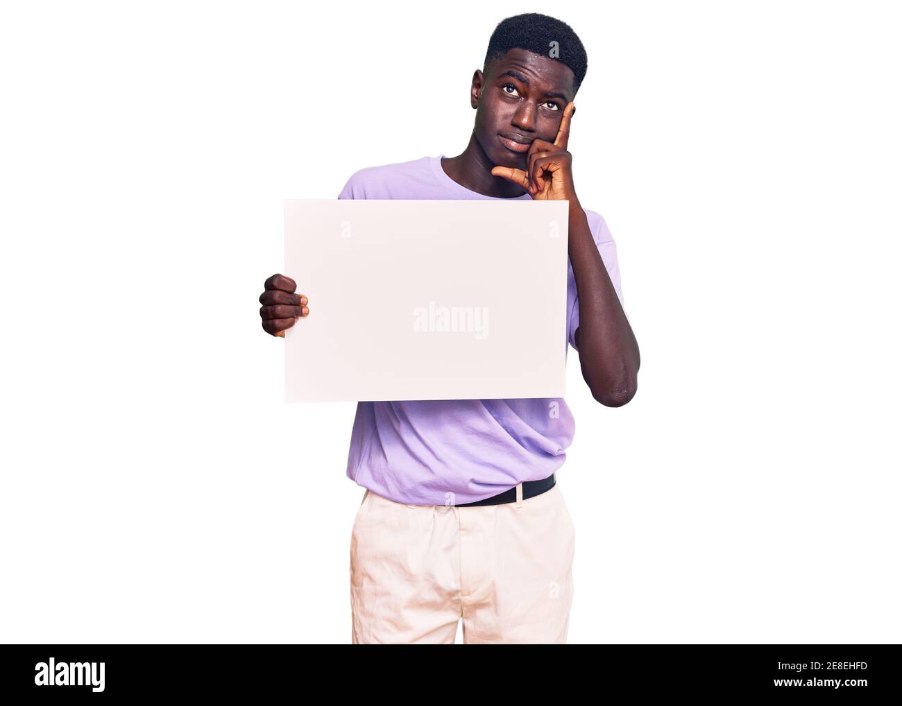Young african american man holding blank empty banner serious face ...