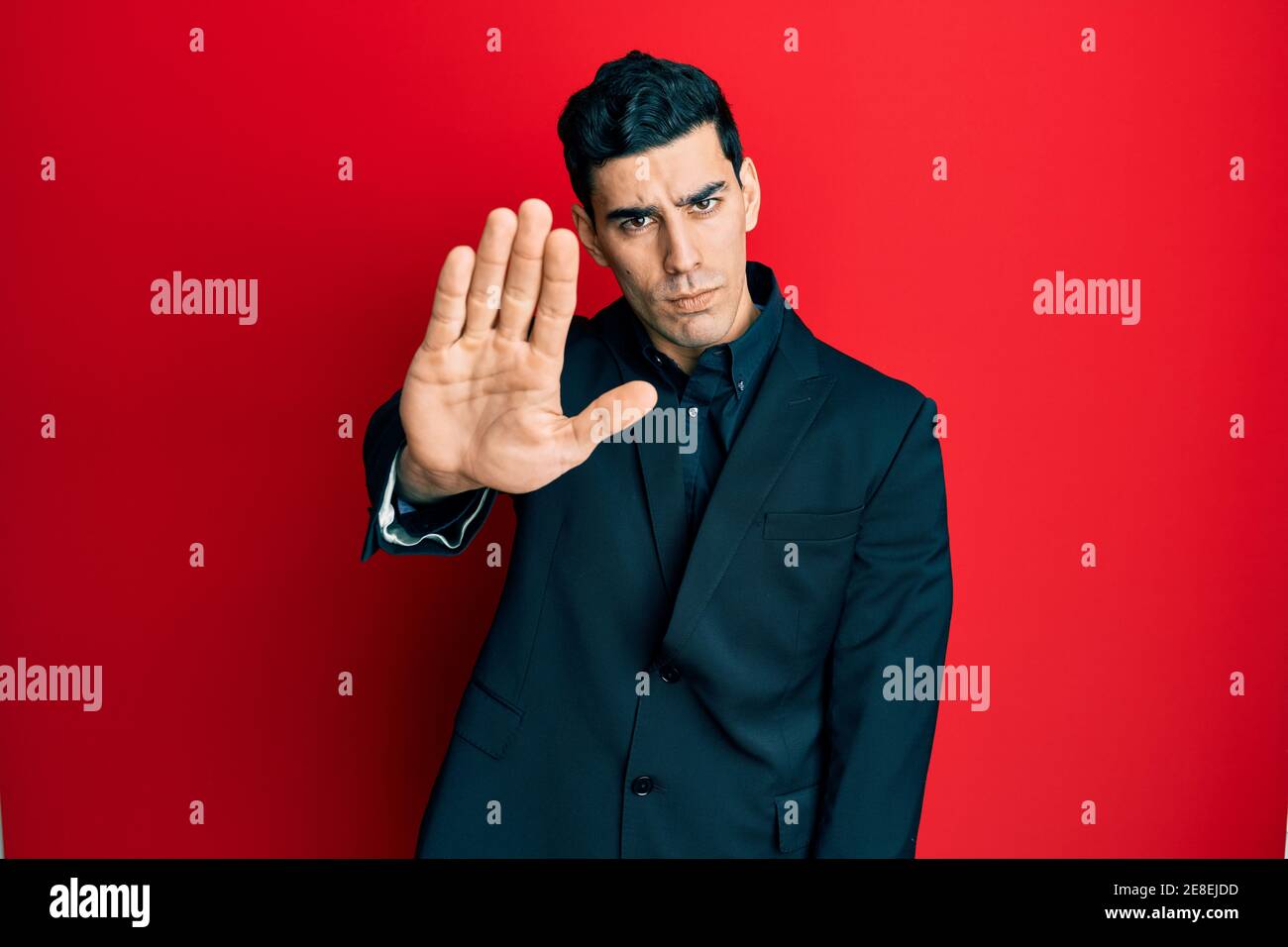 Handsome hispanic man wearing business clothes doing stop sing with ...