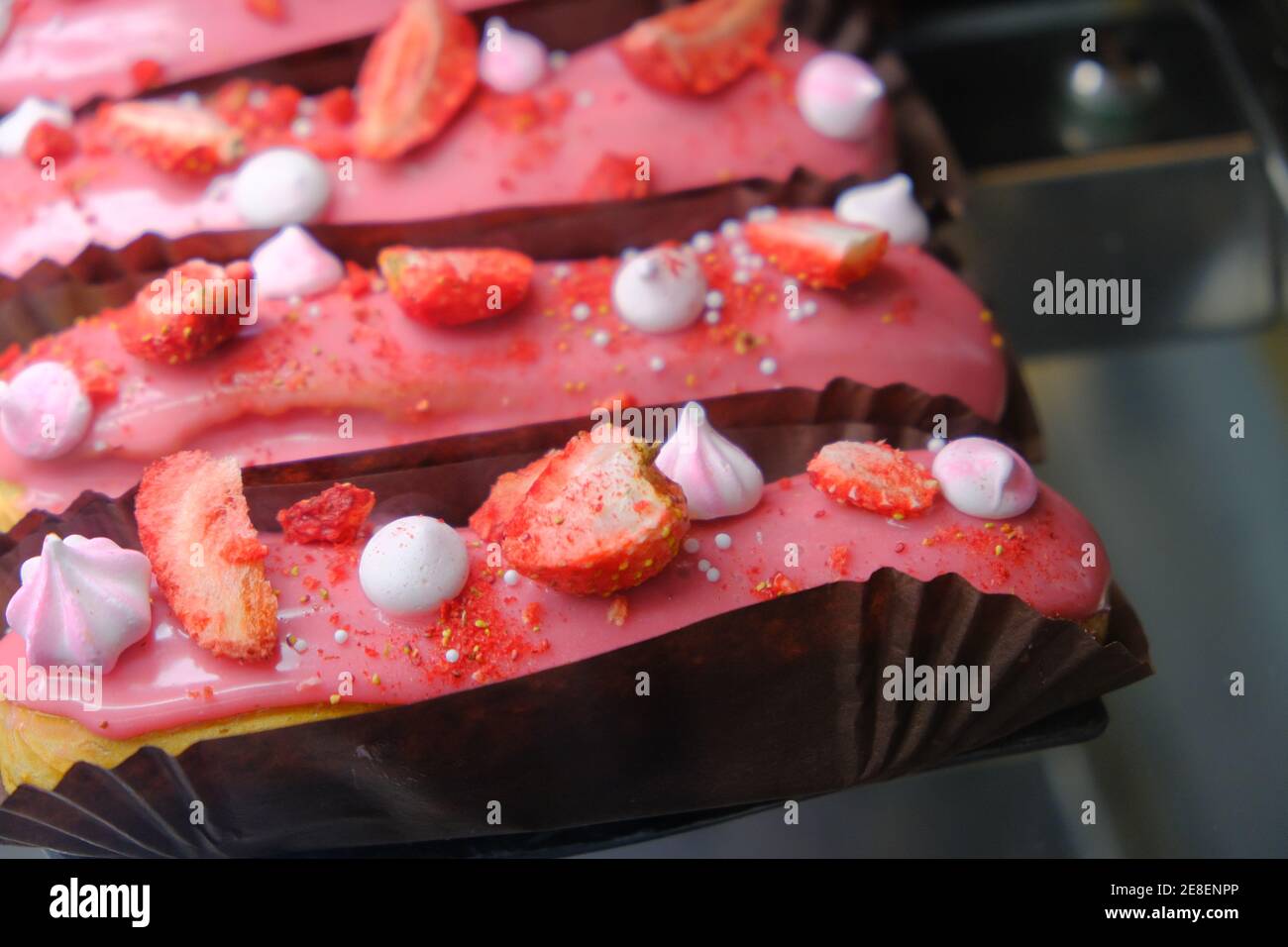 Various types of french dessert eclairs at showcase of cafe shop ...