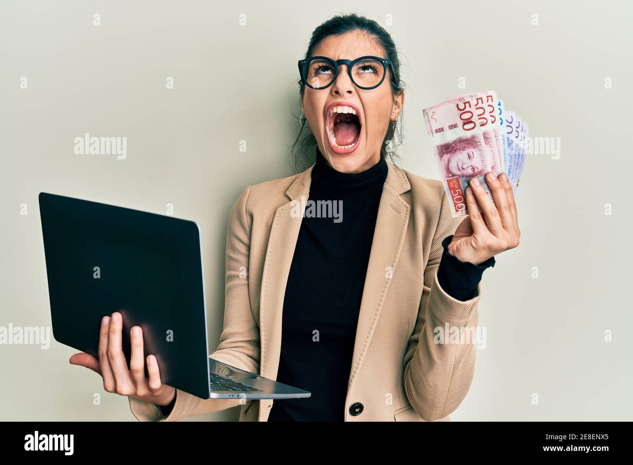 Young hispanic woman wearing business style holding laptop and swedish ...