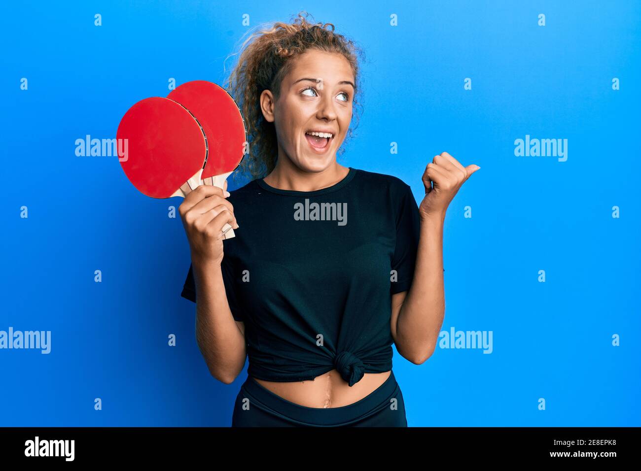 Beautiful caucasian teenager girl holding red ping pong rackets ...