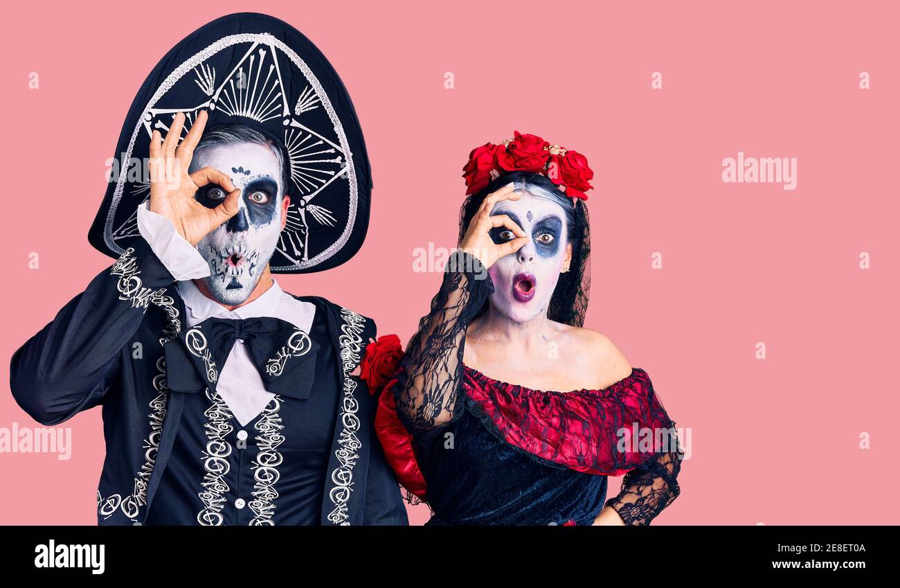 Young couple wearing mexican day of the dead costume over background ...