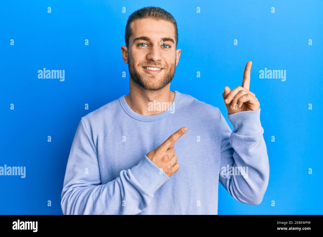 Young caucasian man wearing casual clothes smiling and looking at the ...