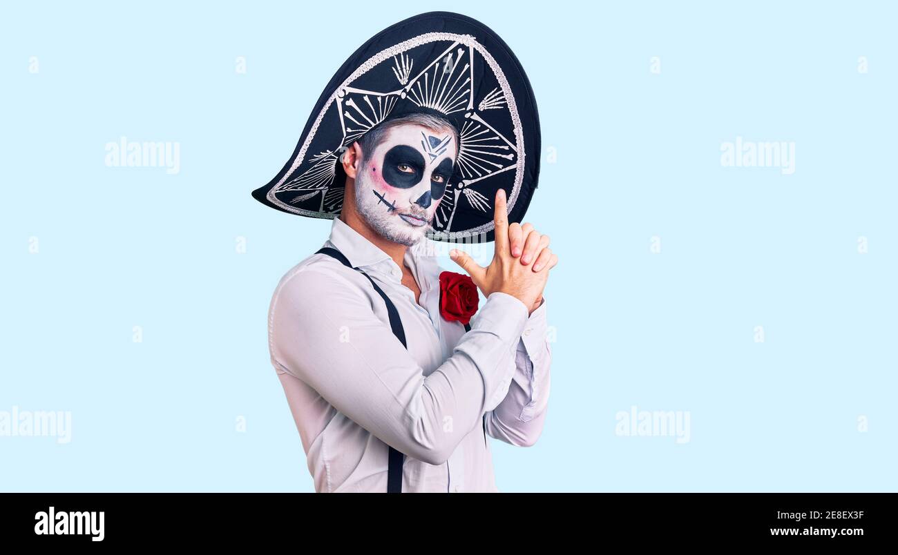 Man wearing day of the dead costume over background holding symbolic ...