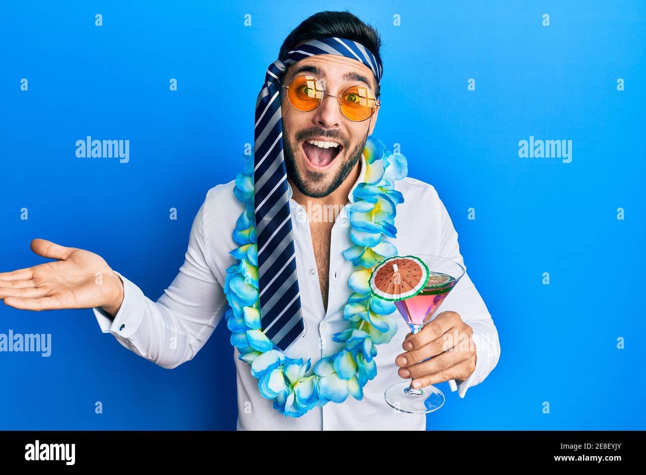 Young hispanic businessman wearing party funny style drinking cocktail ...