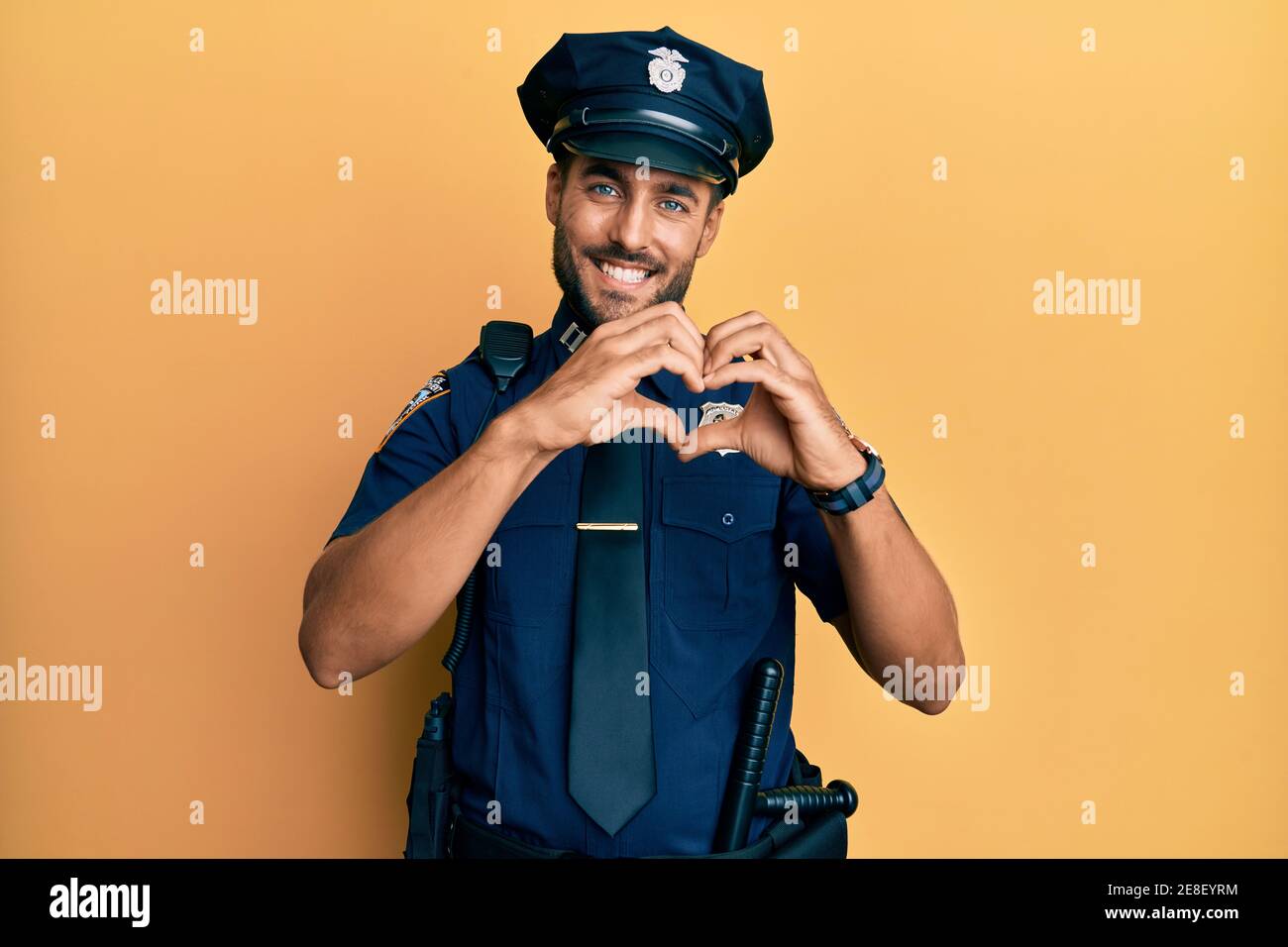 Handsome hispanic man wearing police uniform smiling in love doing ...