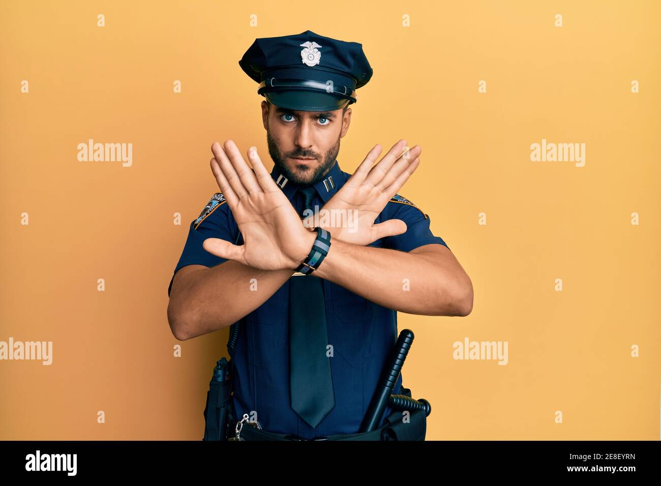 Handsome hispanic man wearing police uniform rejection expression ...