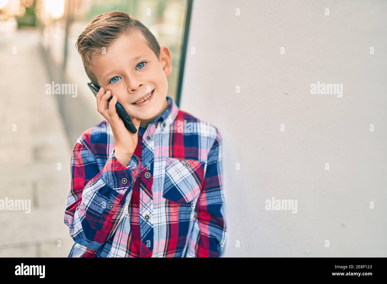 Adorable caucasian boy smiling happy talking on the smartphone at the ...