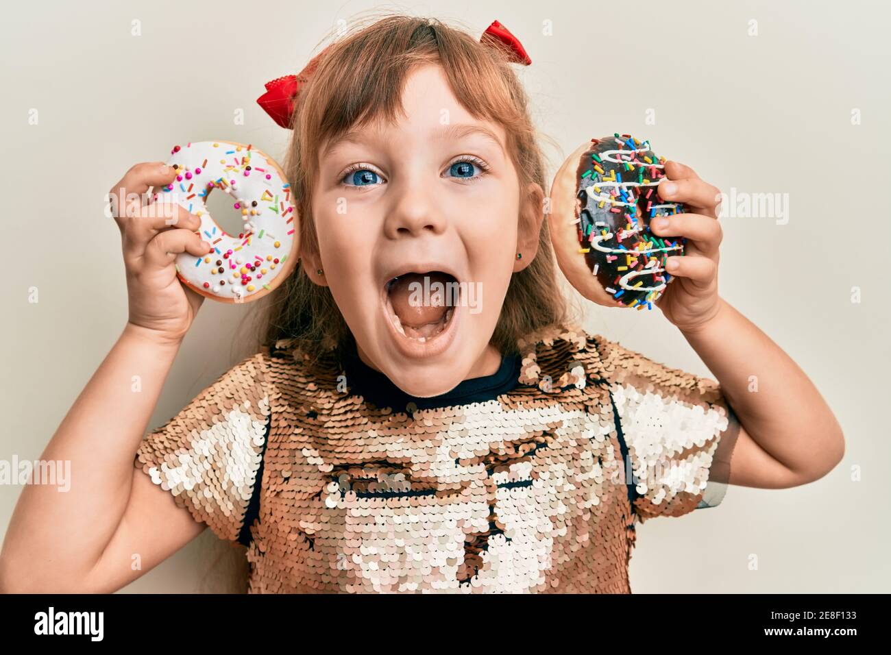 Little caucasian girl kid holding tasty colorful doughnuts celebrating ...