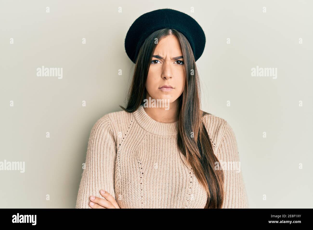 Young brunette woman wearing french look with beret skeptic and nervous ...