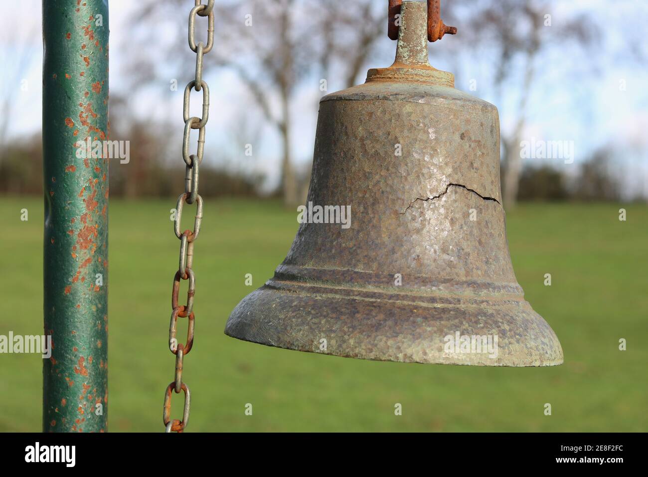 Old metal bell with chain and pole against rural background Stock Photo ...