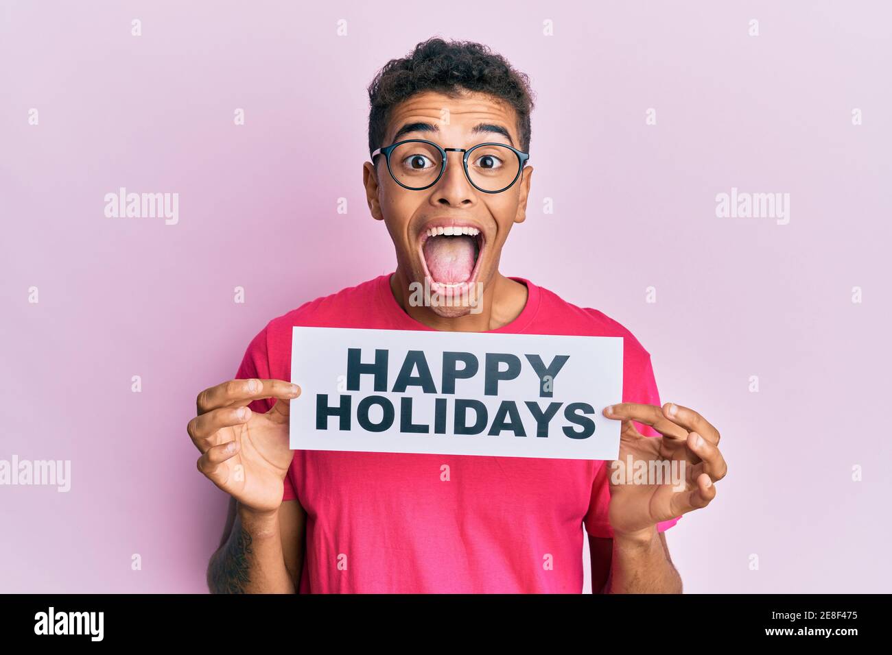 Young handsome african american man holding happy holidays message ...