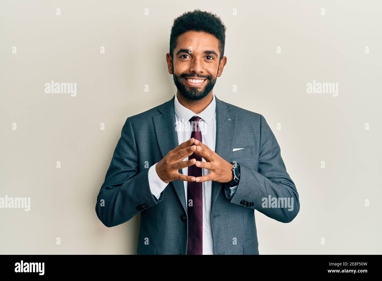 Handsome hispanic man with beard wearing business suit and tie hands ...