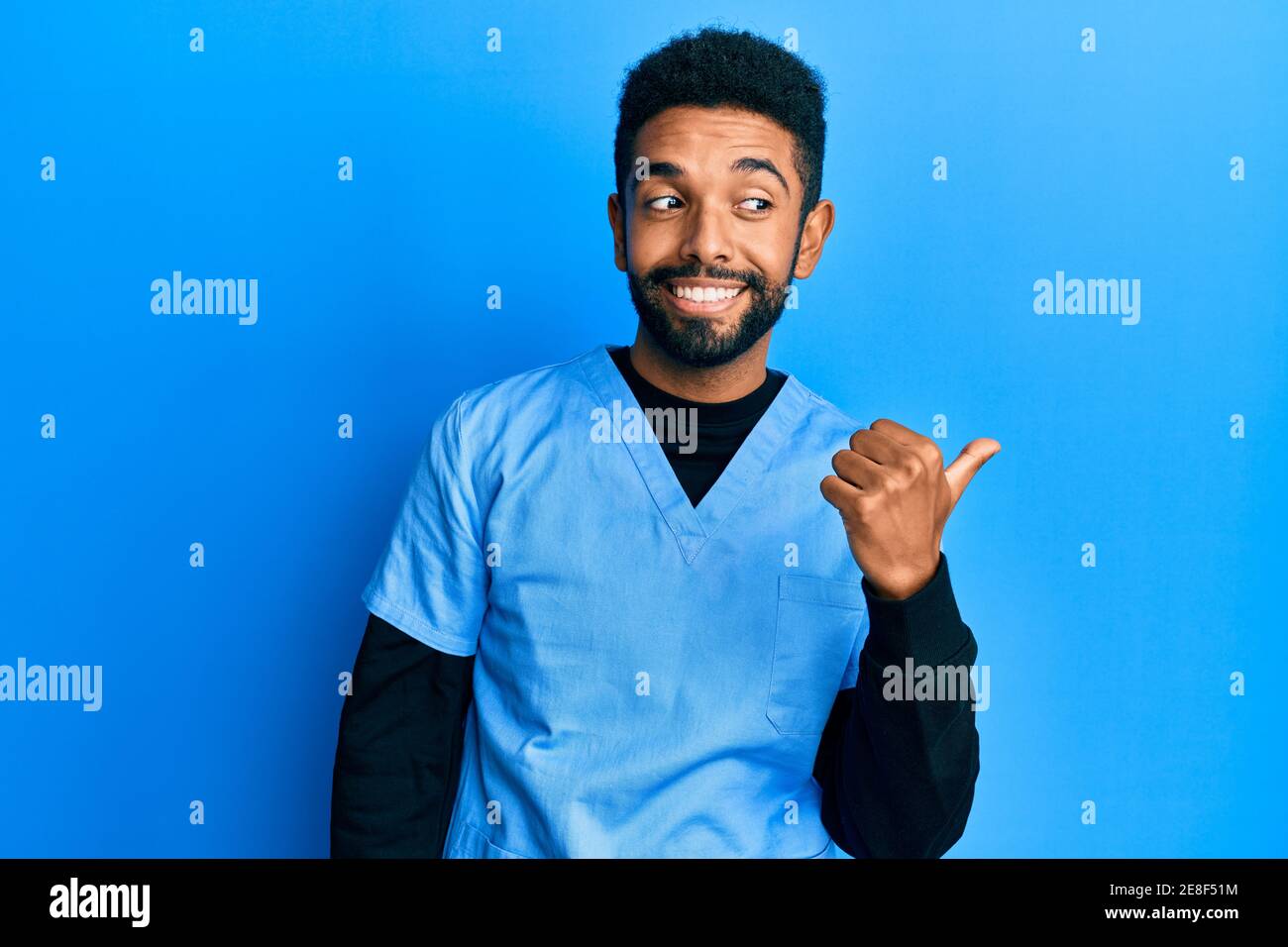 Handsome hispanic man with beard wearing blue male nurse uniform ...