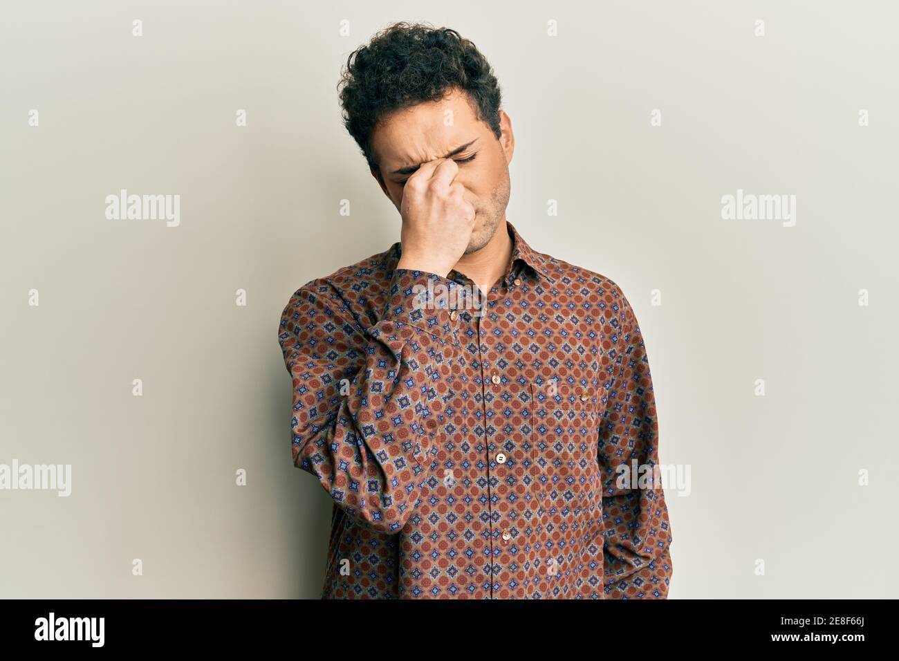 Handsome hispanic man wearing casual clothes tired rubbing nose and ...