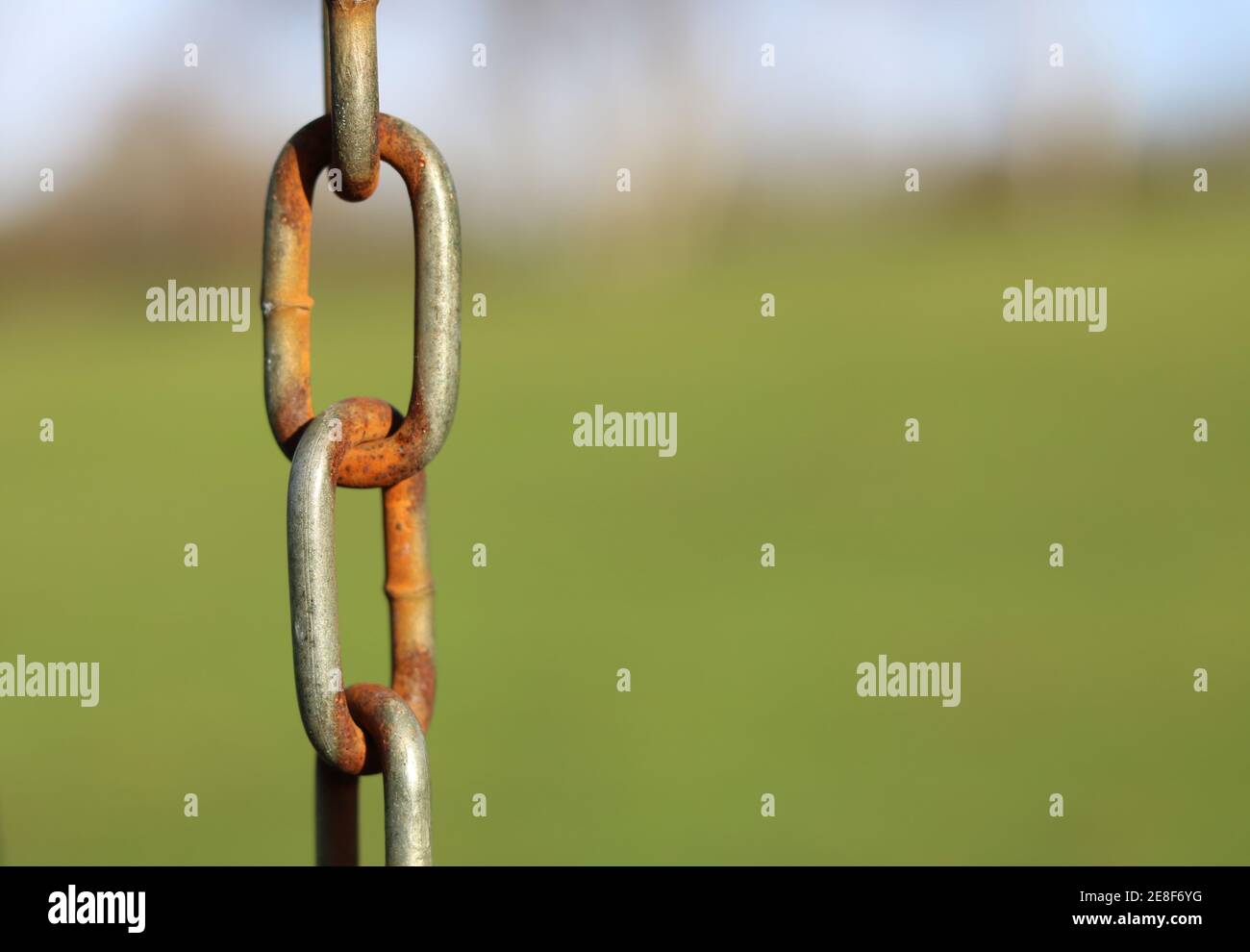 Image of vertical rusty chain with blurred rural background and space ...