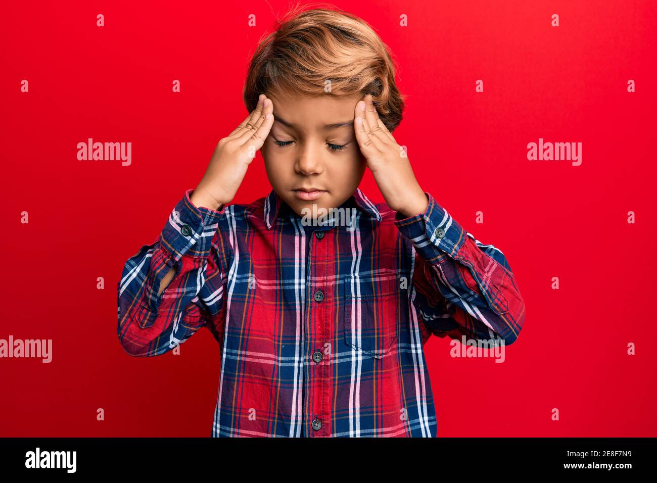 Adorable latin kid wearing casual clothes with hand on head, headache ...