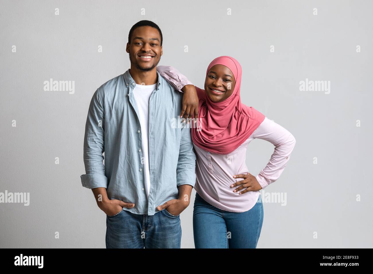 Cheerful loving african american muslim couple posing on grey Stock ...