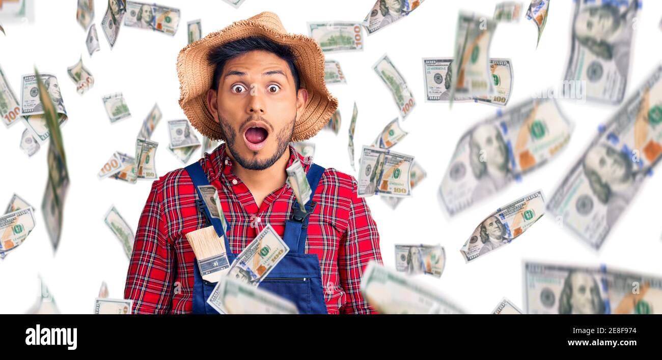 Handsome latin american young man weaing handyman uniform afraid and ...