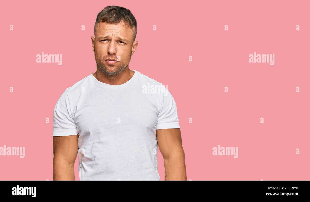 Handsome muscle man wearing casual white tshirt depressed and worry for ...
