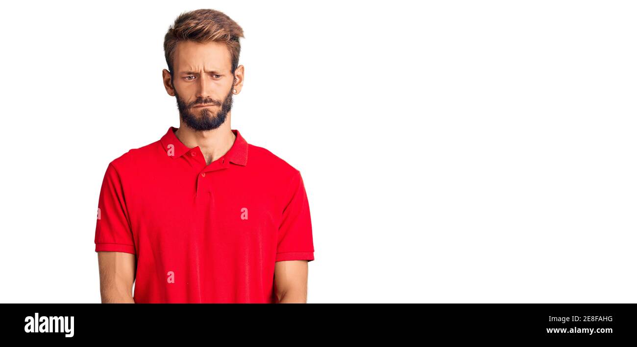 Handsome blond man with beard wearing casual clothes depressed and ...