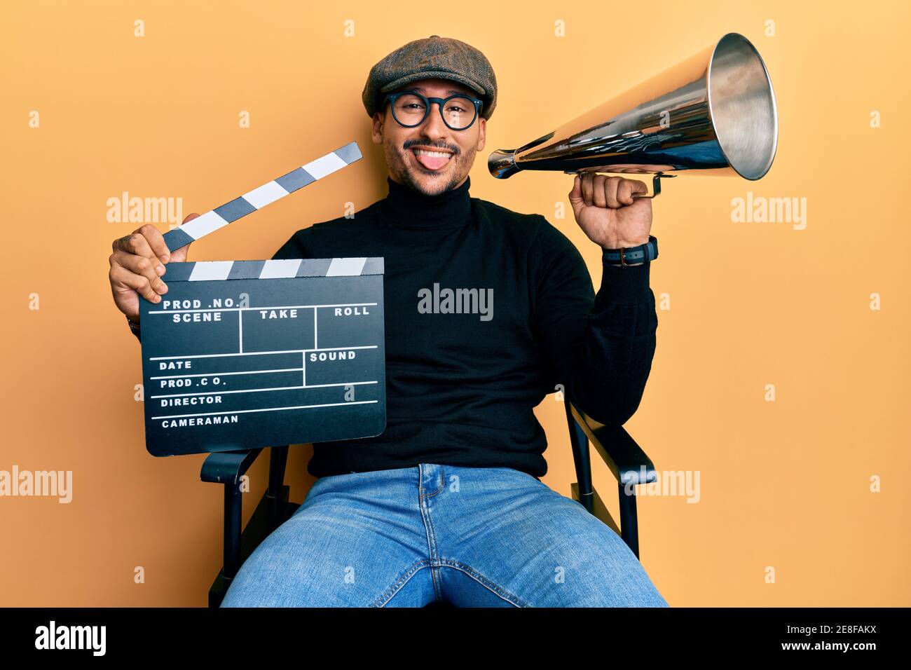 Handsome man with tattoos holding video film clapboard and louder ...