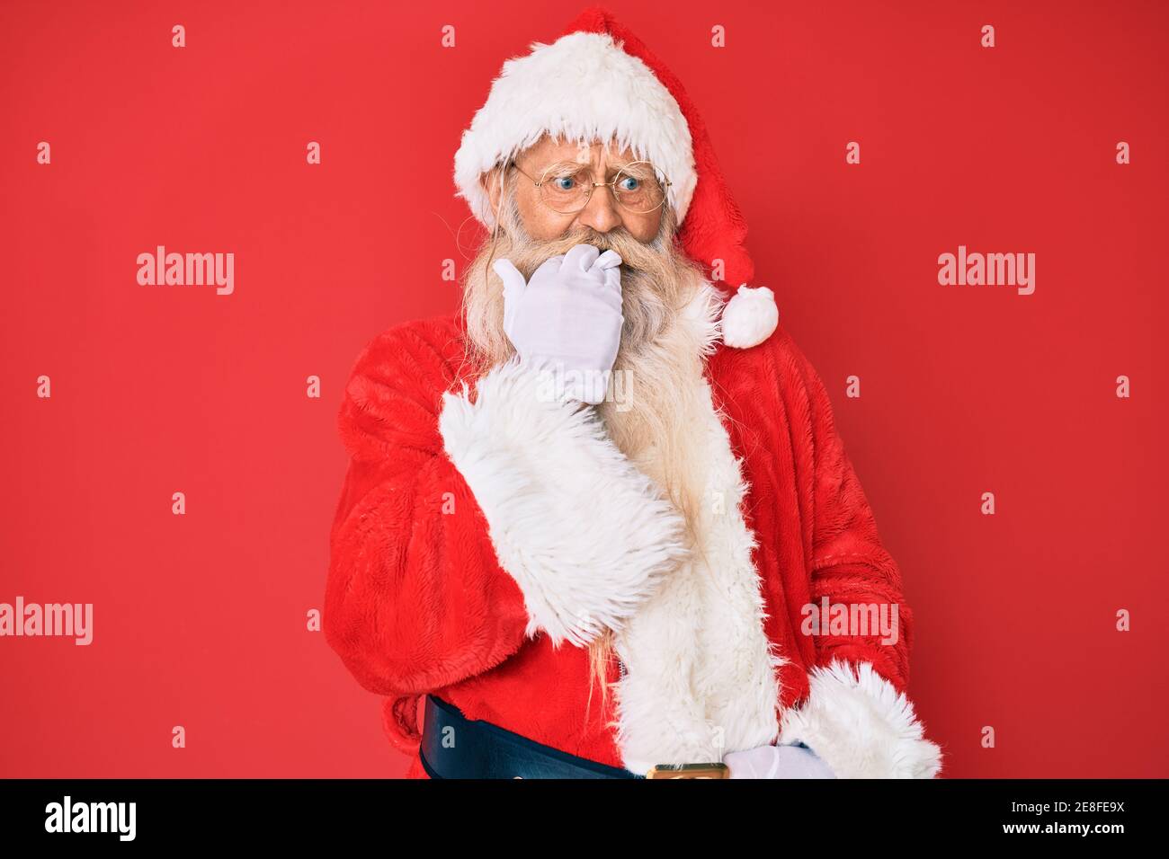 Old senior man with grey hair and long beard wearing traditional santa ...