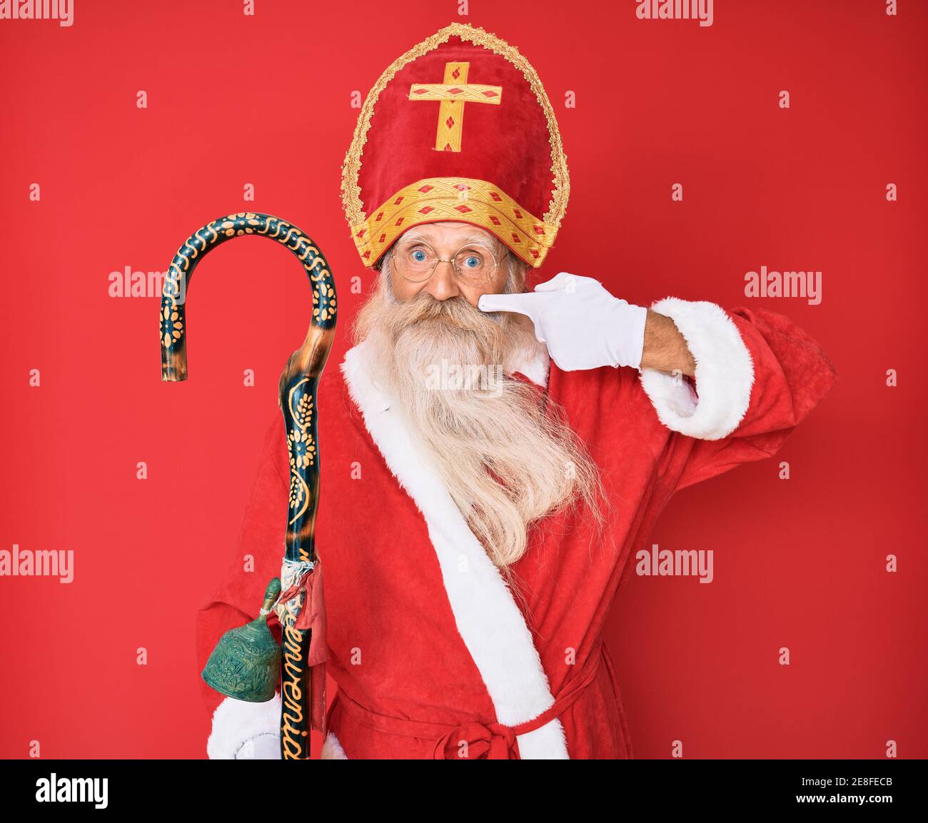 Old senior man with grey hair and long beard wearing traditional saint ...