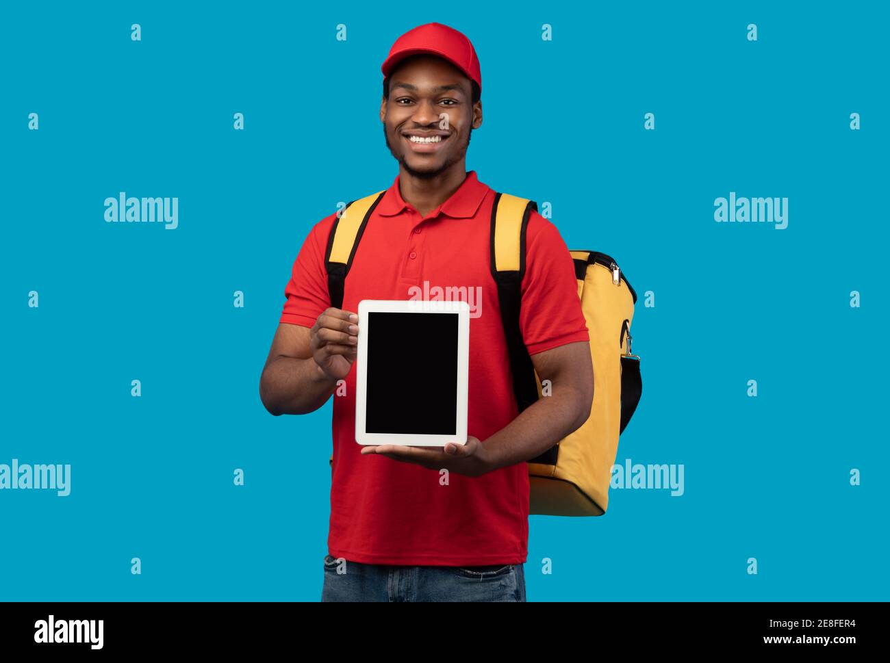 Black delivery man holding tablet with blank screen for mockup Stock ...