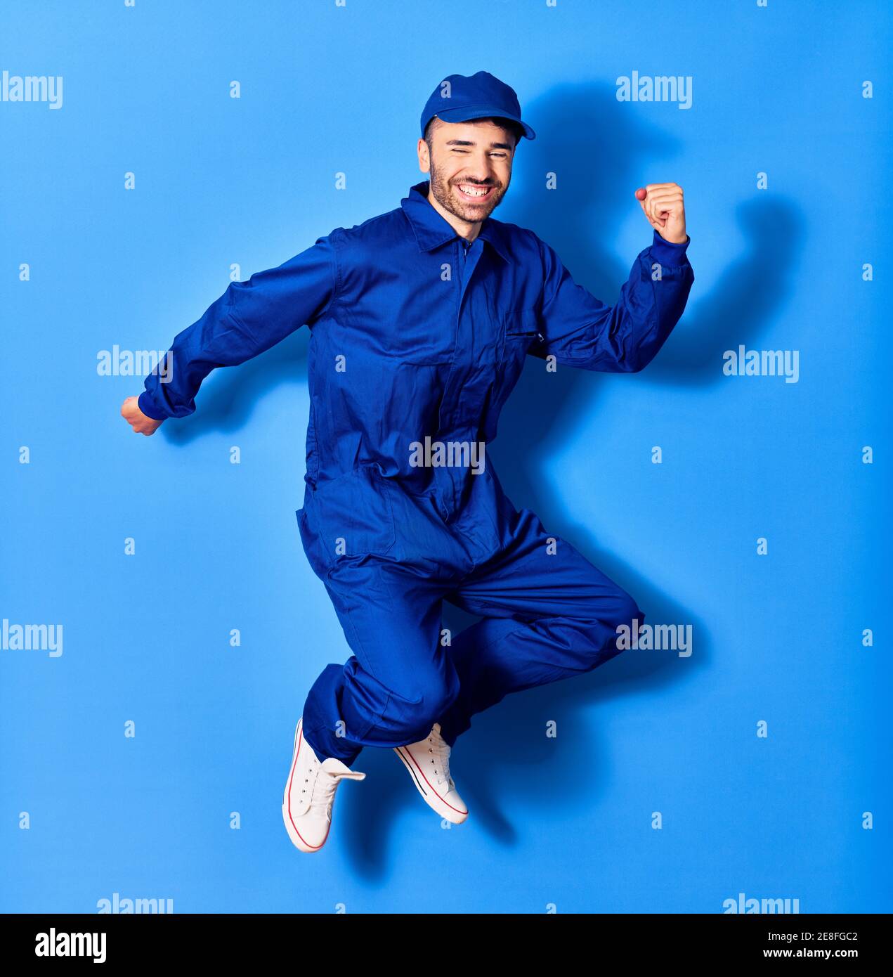 Young handsome hispanic man wearing painter uniform and cap smiling ...