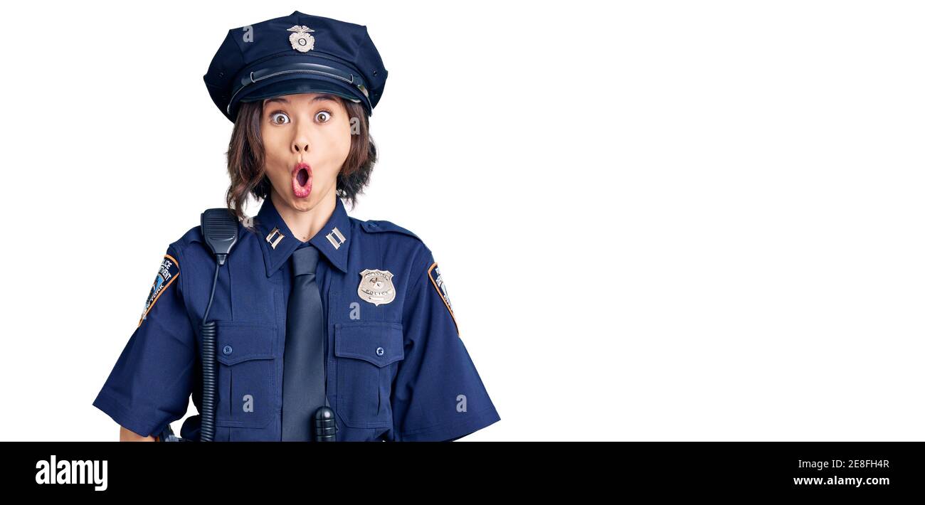 Young beautiful girl wearing police uniform afraid and shocked with ...