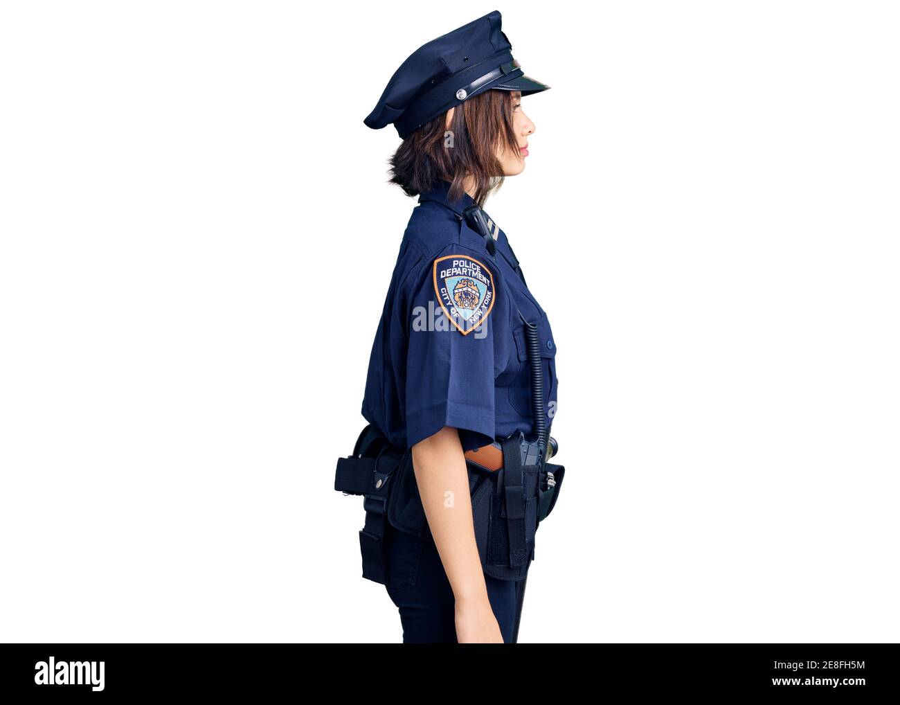 Young beautiful girl wearing police uniform looking to side, relax ...